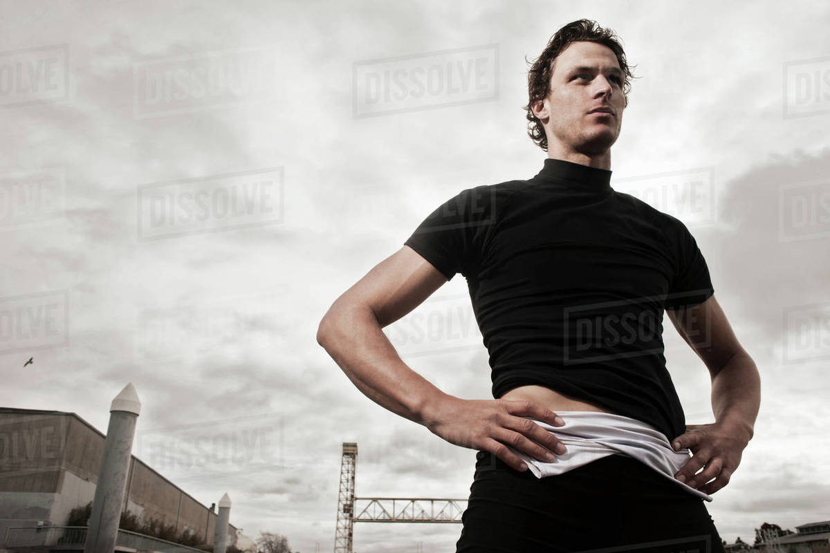 Runner standing on urban waterfront - Royalty-free Stock Photo | Dissolve