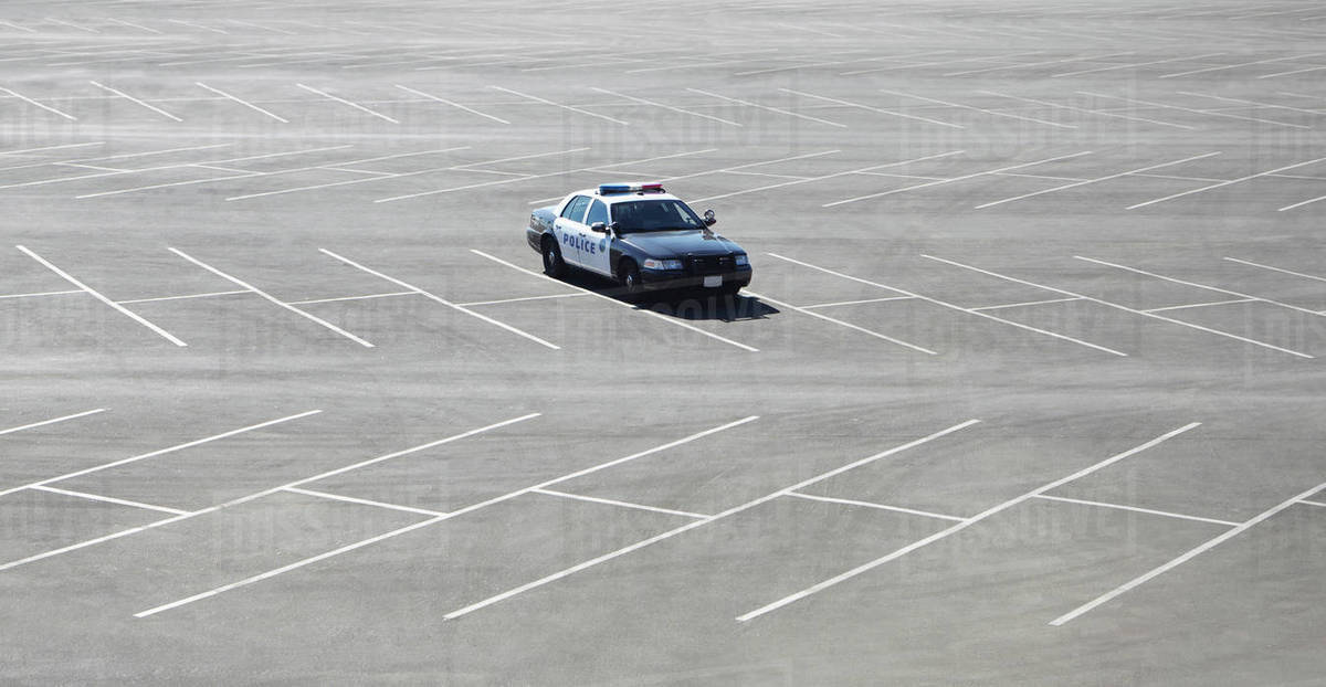 Police car parked in empty lot - Royalty-free Stock Photo | Dissolve