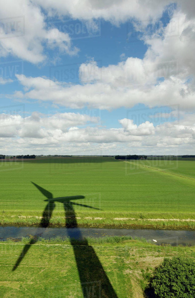 Shadow of a wind turbine on the meadow - Stock Photo - Dissolve