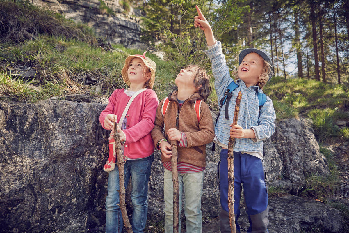 Three children in forest, standing together, looking up - Royalty-free ...