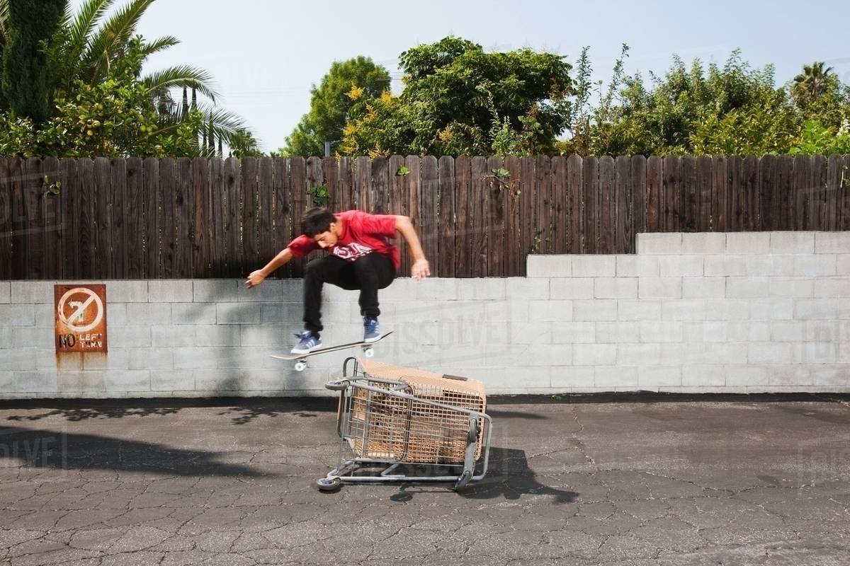 Man on skateboard jumping over a shopping trolley - Royalty-free Stock ...