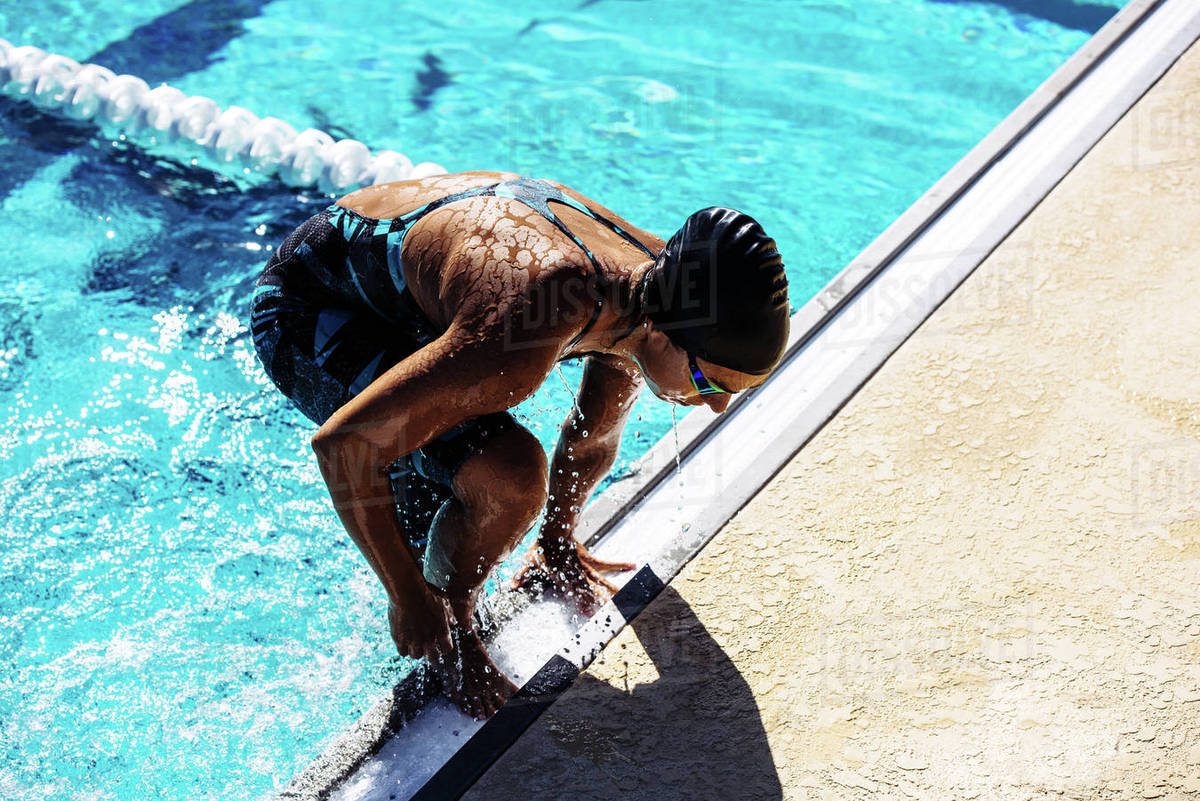 Swimmer climbing out of pool - Stock Photo - Dissolve