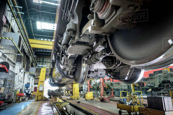 Underside of locomotive in train works - Stock Photo - Dissolve