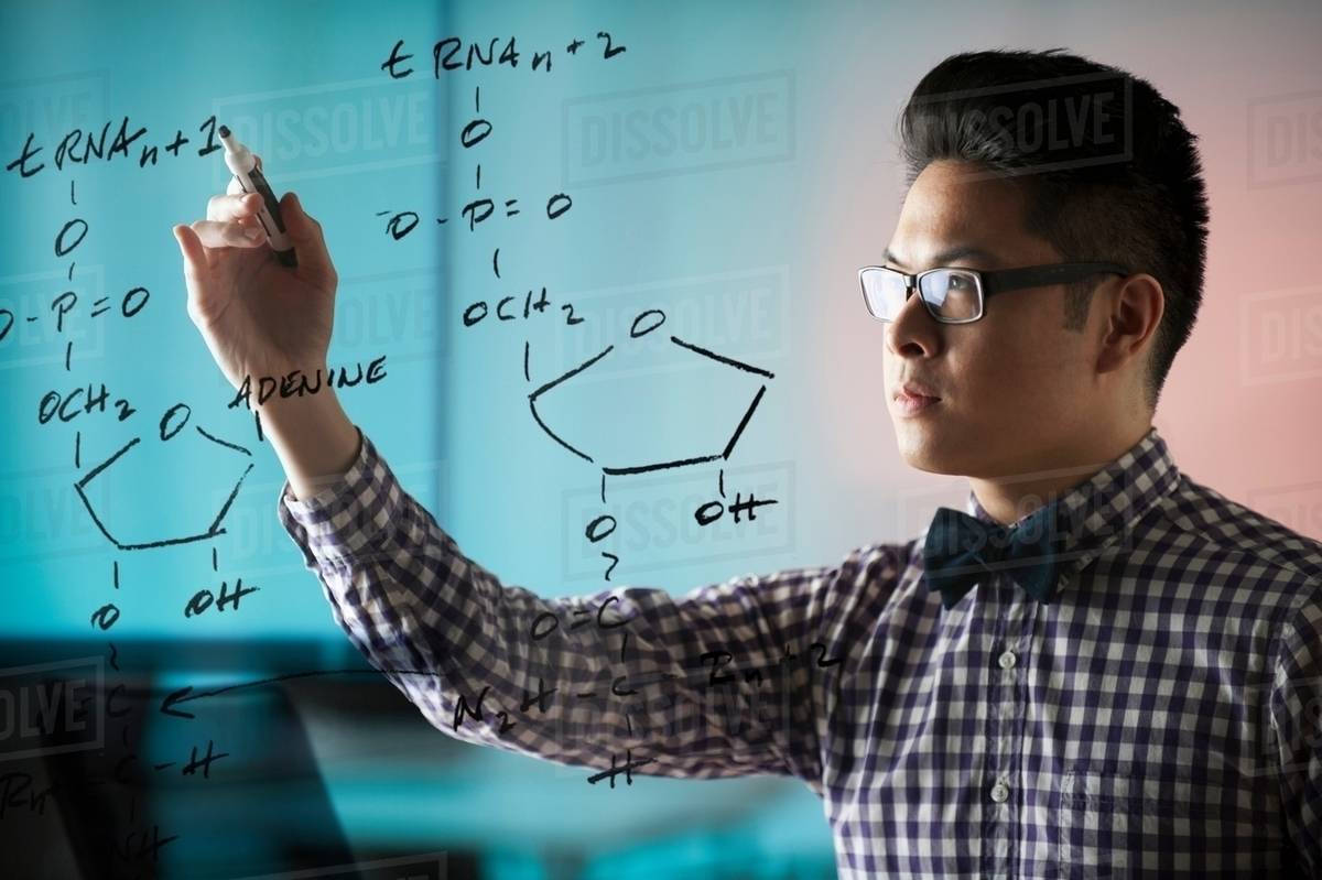 Young man drawing diagram on window - Stock Photo - Dissolve