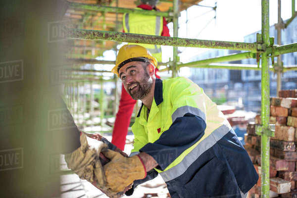 Construction workers moving bricks - Stock Photo - Dissolve