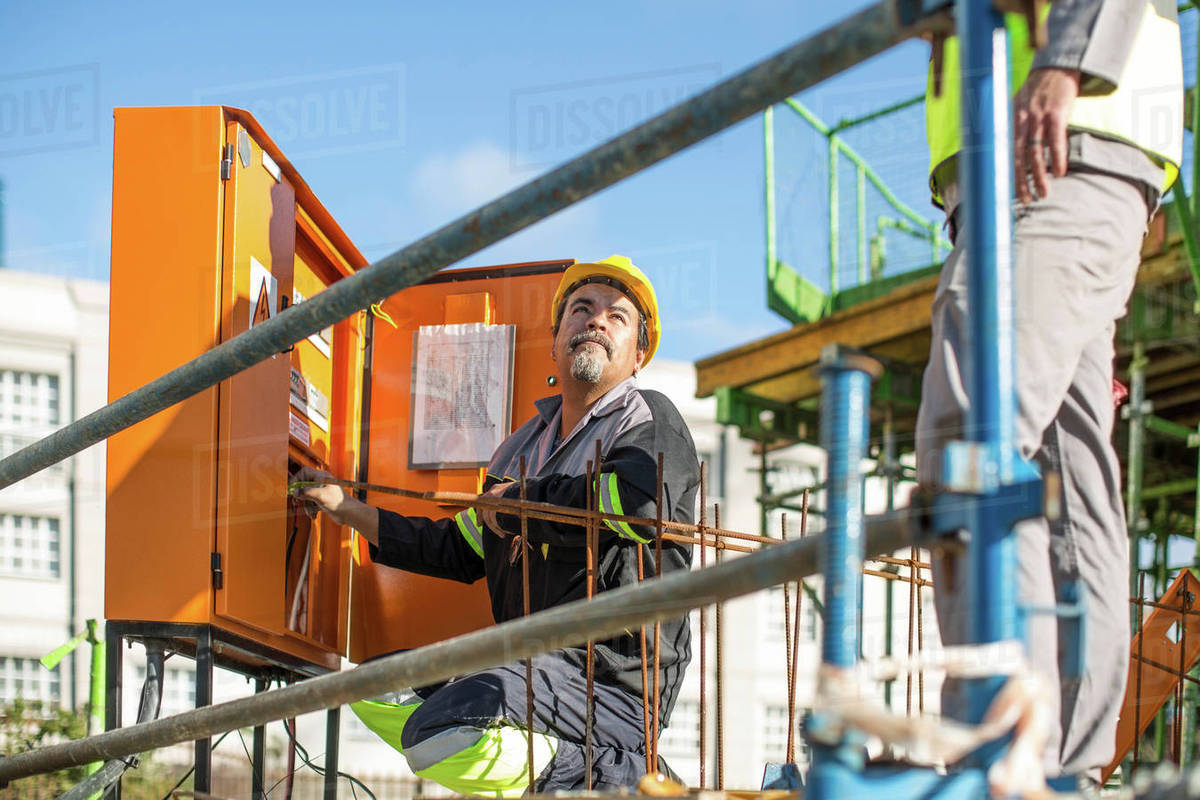 Construction worker checking machine - Stock Photo - Dissolve