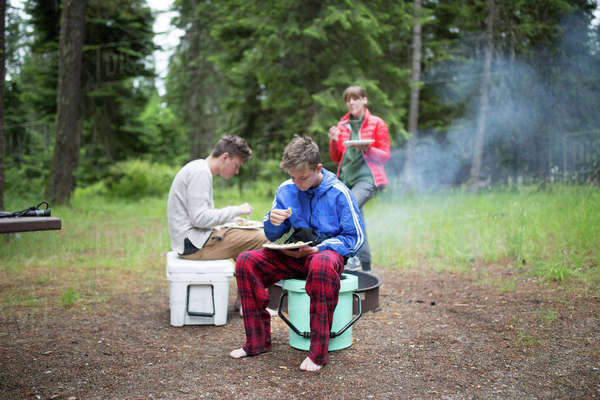 Family in rural setting, camping, eating meal - Stock Photo - Dissolve