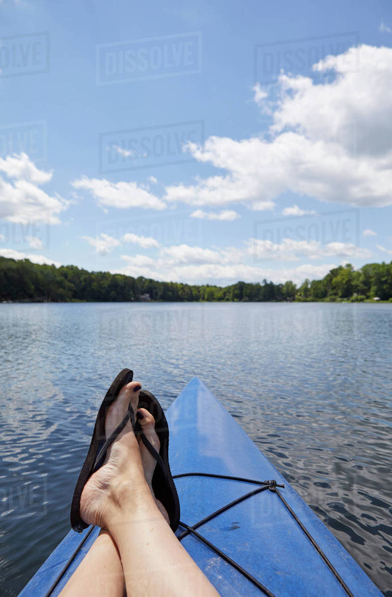 Woman relaxing on canoe, on lake, low section - Royalty-free Stock ...