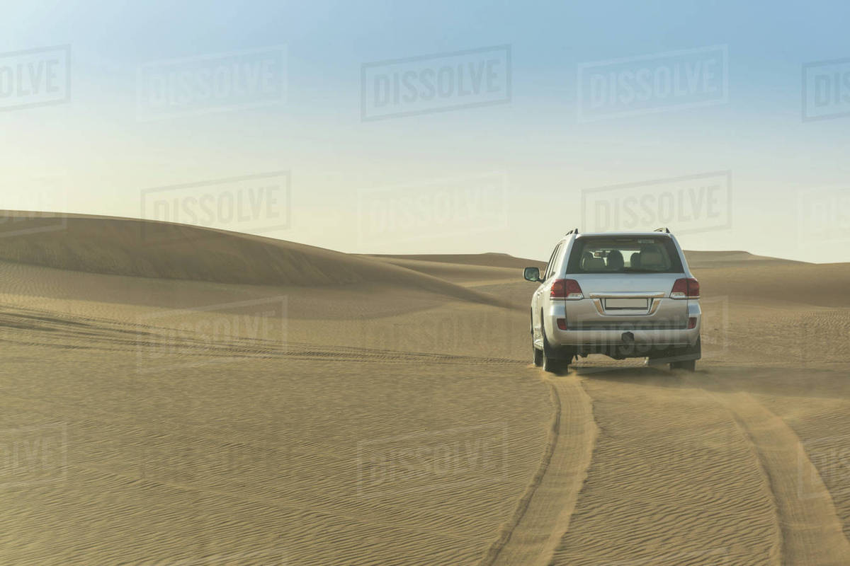 Off road vehicle driving over desert dunes, Dubai, United Arab Emirates ...