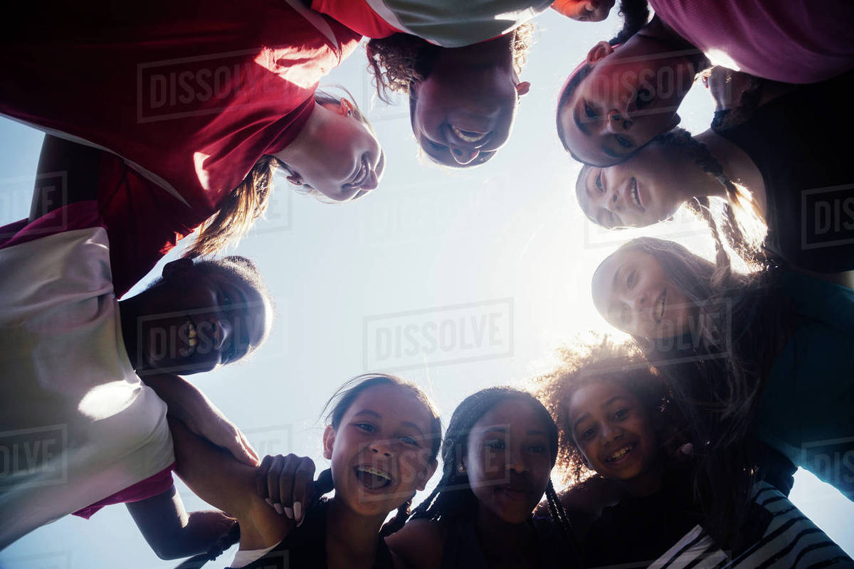 Low angle view of schoolgirl soccer team huddled in circle - Royalty ...