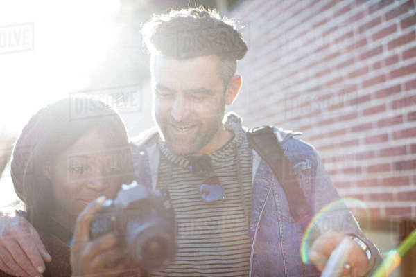 Man and woman outdoors, looking at back of digital camera - Royalty ...