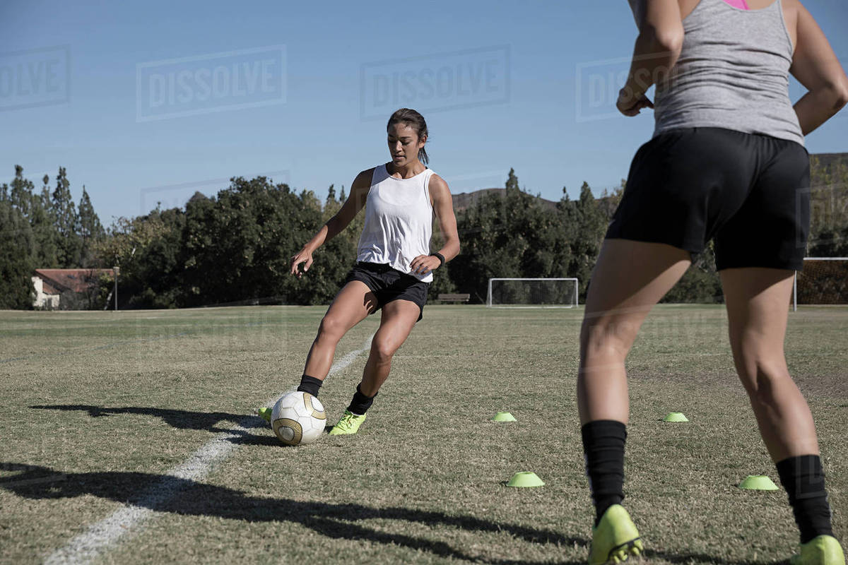 Women on football pitch playing football - Stock Photo - Dissolve
