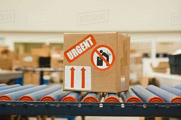 Cardboard box with warning stickers on conveyor belt - Royalty-free ...