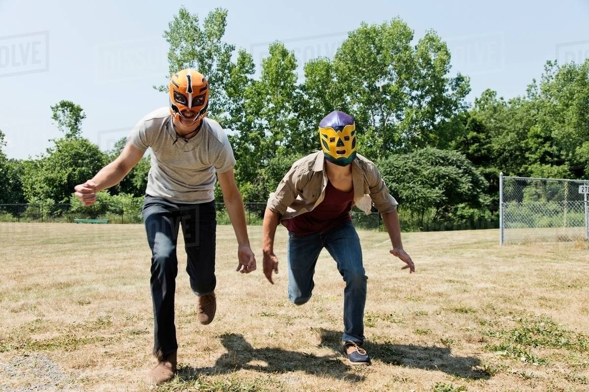 Two young men wearing wrestling masks - Stock Photo - Dissolve