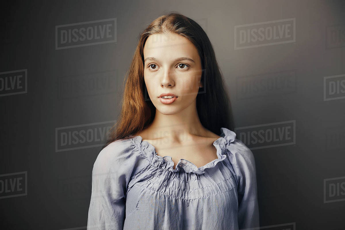 Young woman, grey background - Stock Photo - Dissolve