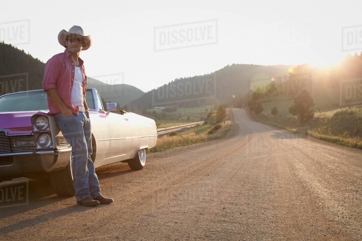 Man in cowboy hat, leaning against convertible car - Royalty-free Stock ...