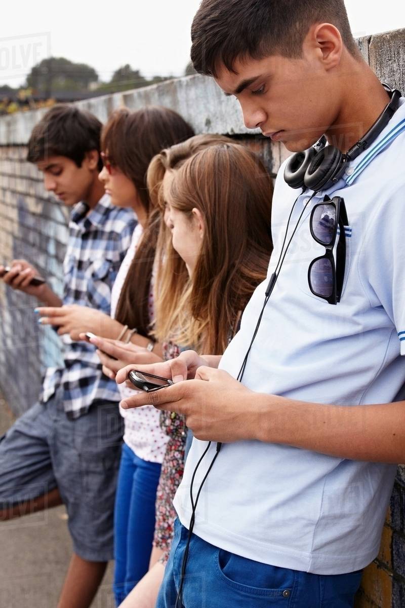 Teenagers using cellphones - Royalty-free Stock Photo | Dissolve