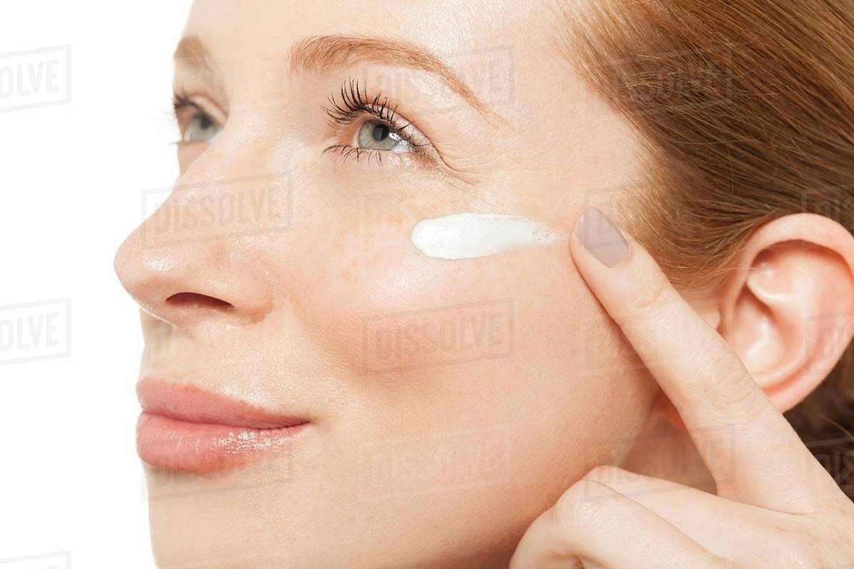 Woman applying moisturiser - Royalty-free Stock Photo | Dissolve