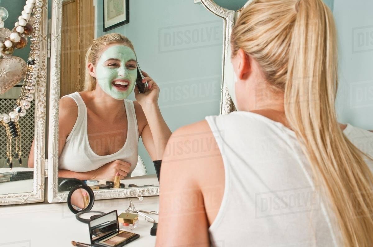 Woman in face mask on the phone - Royalty-free Stock Photo | Dissolve