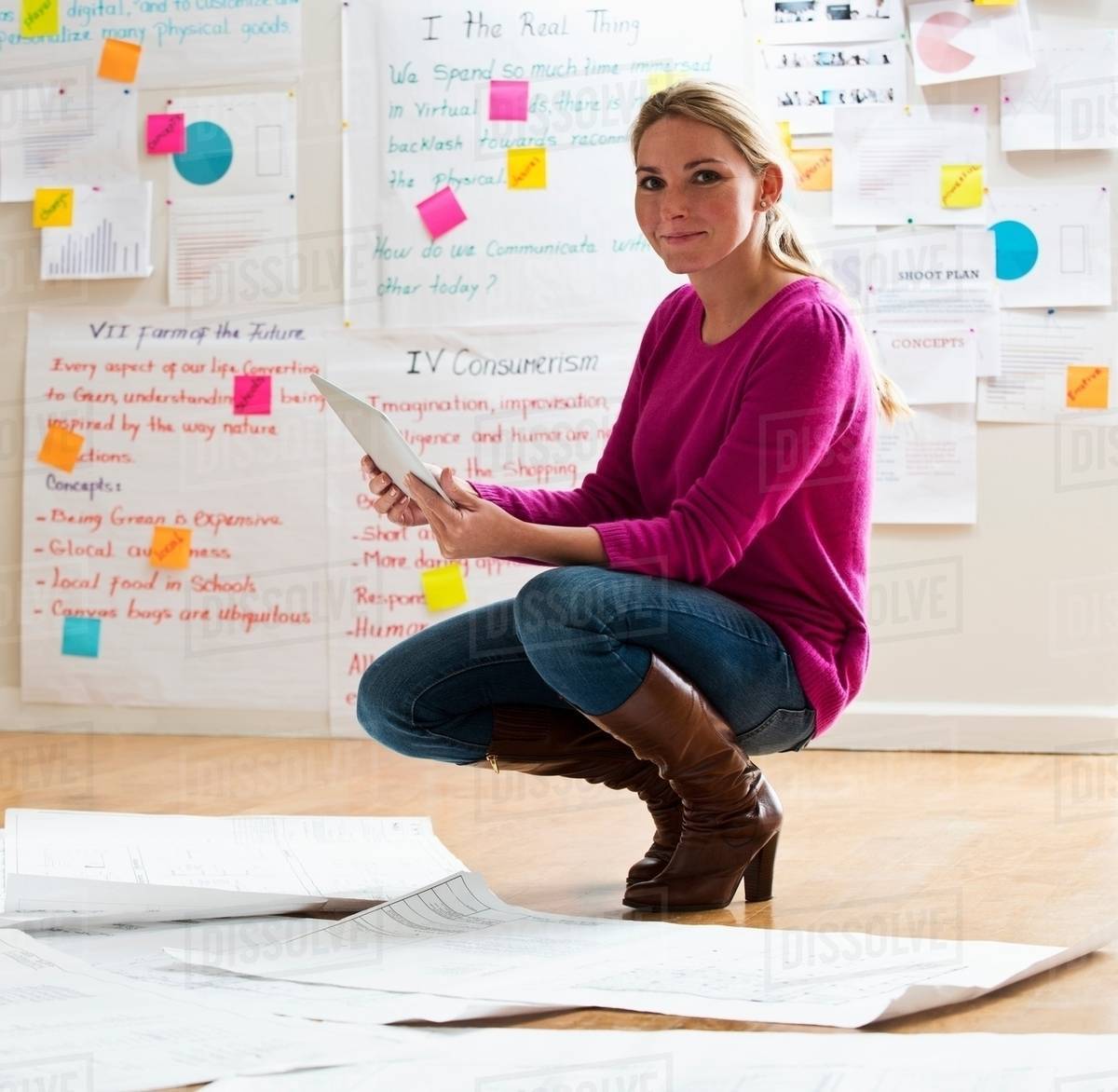 Woman crouching with digital tablet - Stock Photo - Dissolve