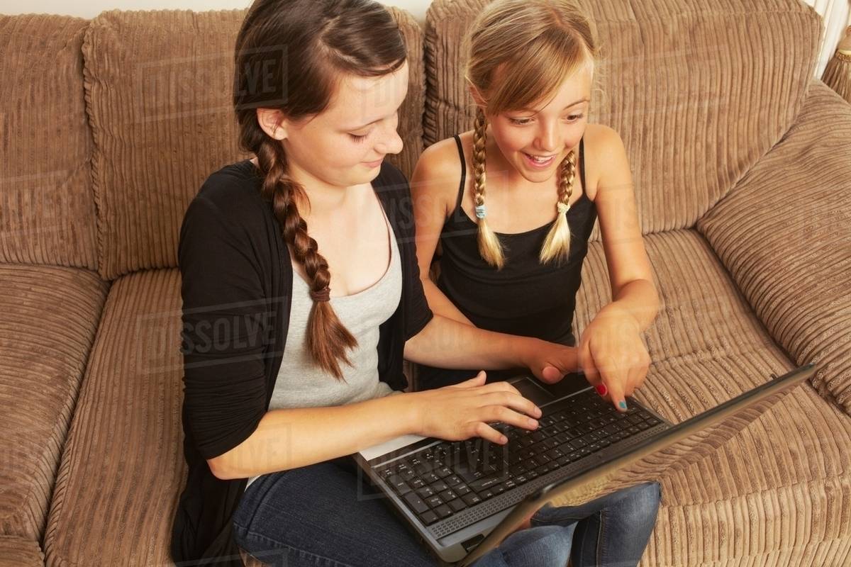 Two girls using laptop - Stock Photo - Dissolve