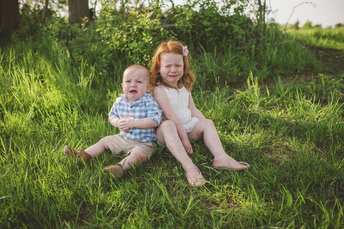 Young children crying on grass - Royalty-free Stock Photo | Dissolve
