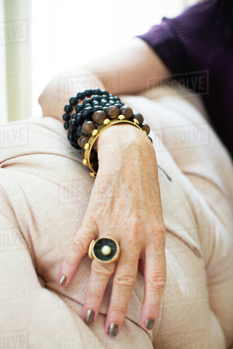 Stylish mature woman wearing bead bracelets and ring, close up of hand ...