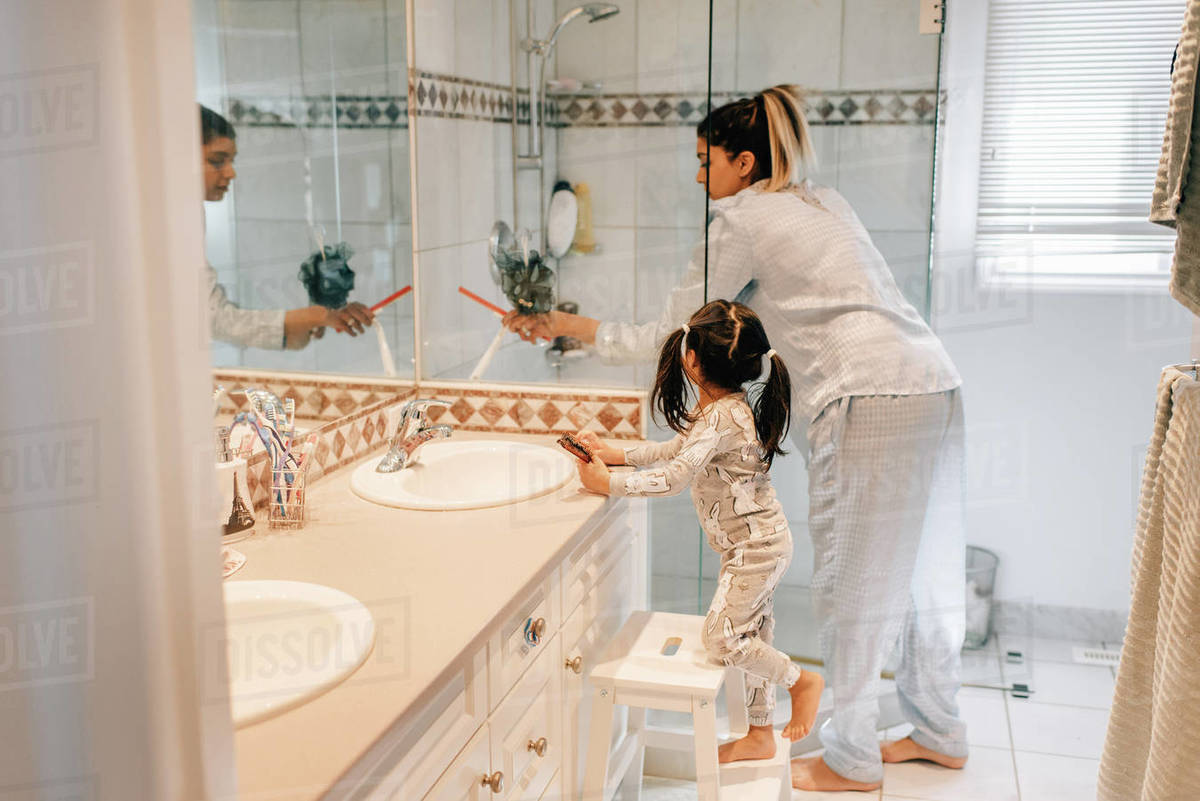 Girl and mother getting ready in bathroom - Stock Photo - Dissolve