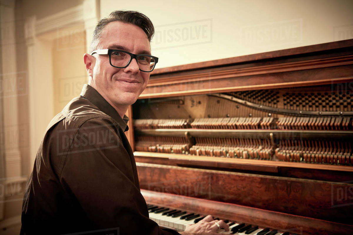 Man smiling and playing piano - Royalty-free Stock Photo | Dissolve