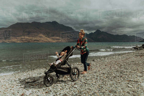 Mother with baby in pram walking on beach, Queenstown, Canterbury, New ...