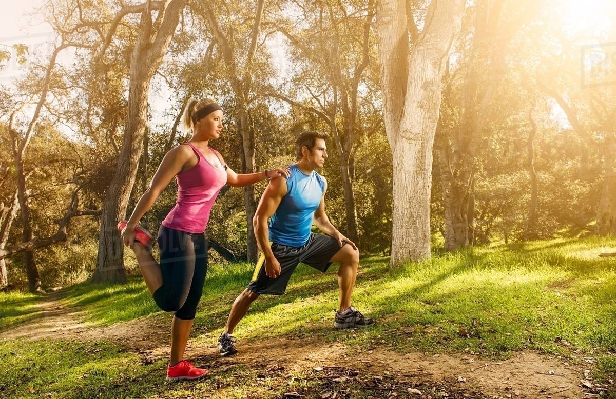 Two people exercising in forest doing warm up stretches - Stock Photo ...