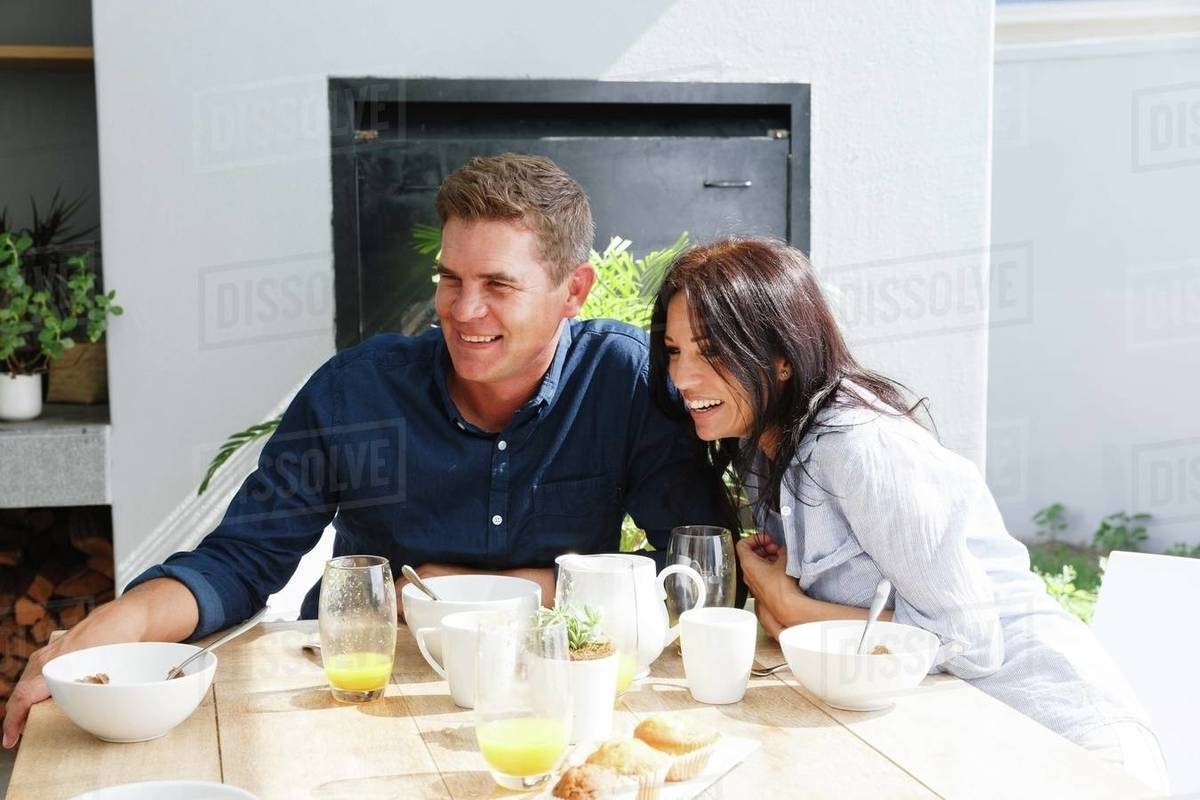 Couple having lunch and smiling at home - Stock Photo - Dissolve