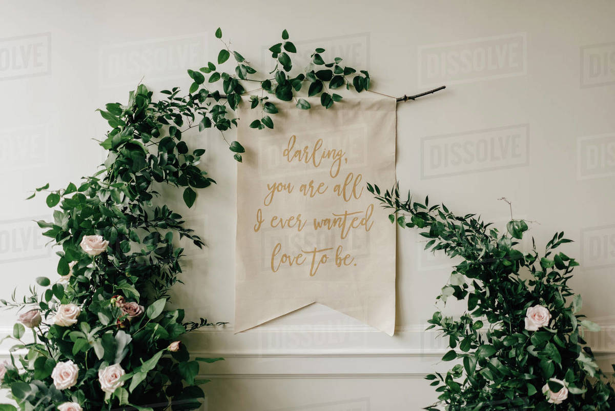 Romantic message on textile, hanging from floral foliage decoration at ...