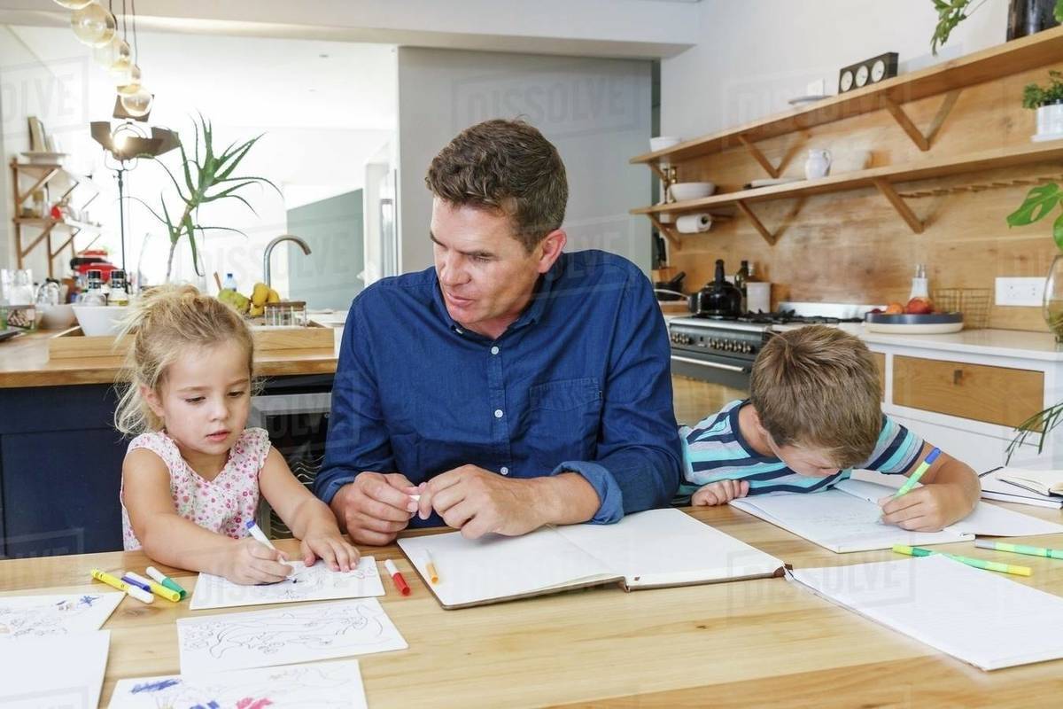 Father helping children with homework at home - Royalty-free Stock ...