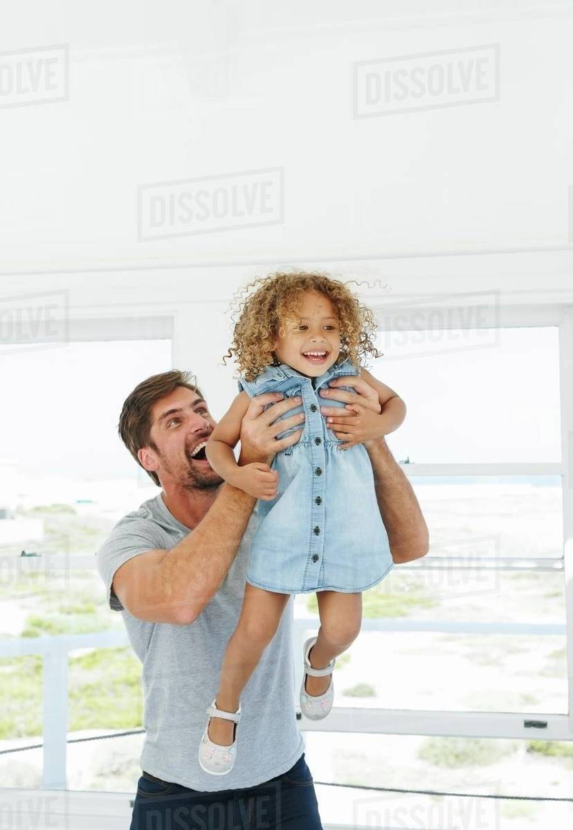Father lifting daughter in mid air in beach house - Royalty-free Stock ...
