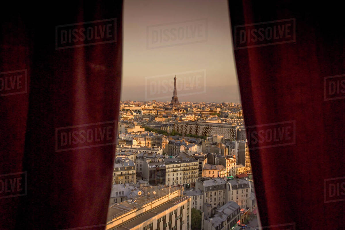 Red curtained window view of cityscape with distant Eiffel Tower, Paris ...