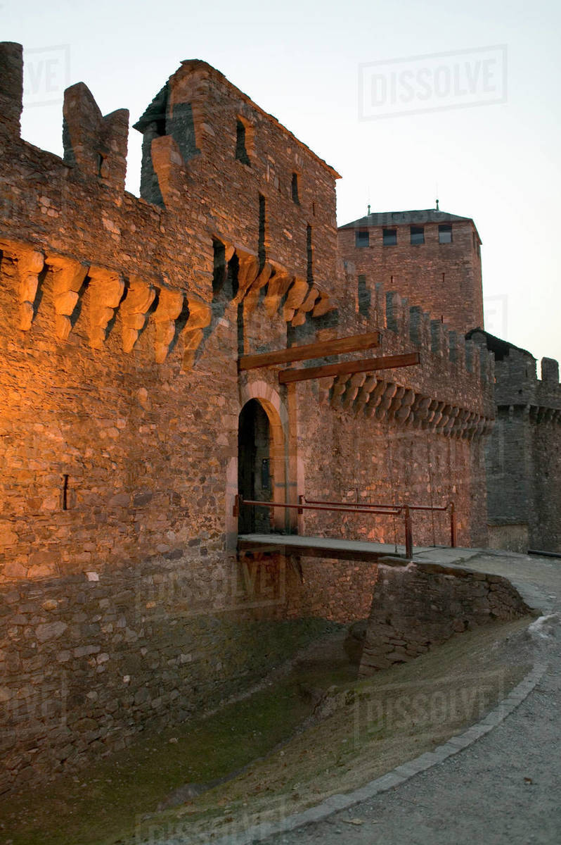 Entrance and drawbridge of Bellinzona city wall illuminated at night ...