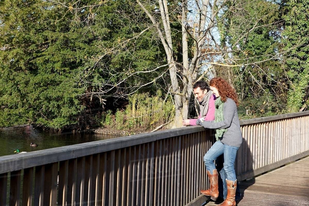 A couple look out over the water from a bridge - Royalty-free Stock ...