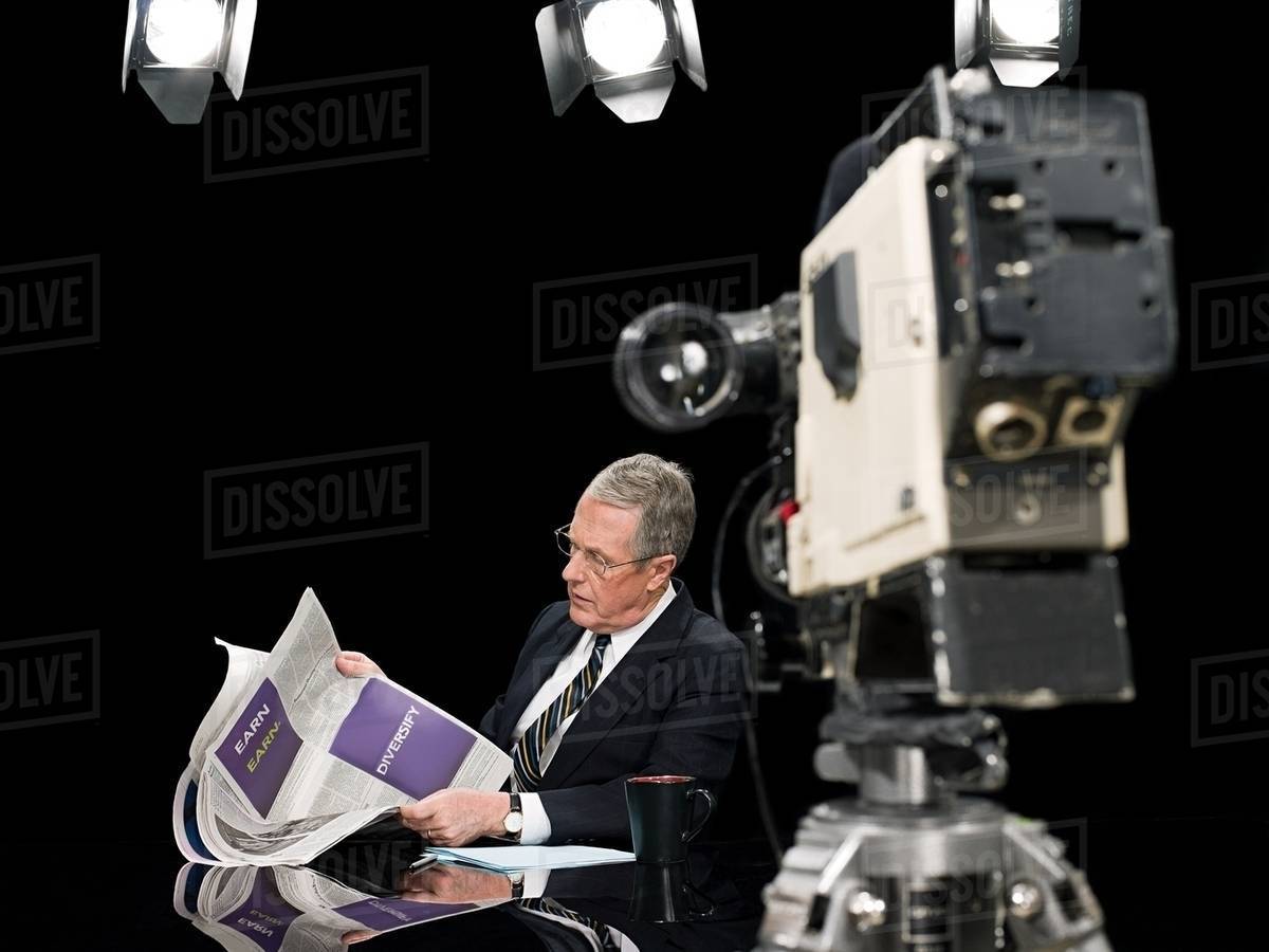 News presenter reading newspaper - Royalty-free Stock Photo | Dissolve
