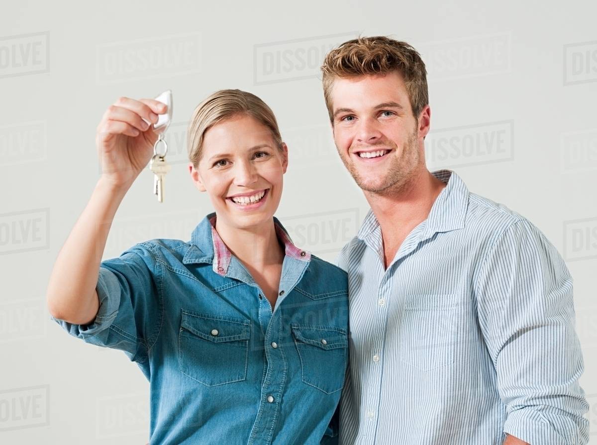 Young couple holding house keys - Stock Photo - Dissolve