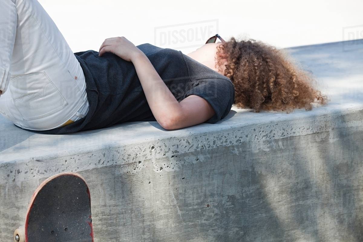 Young woman lying on wall - Royalty-free Stock Photo | Dissolve