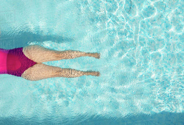 Overhead view of a woman in swimming pool - Stock Photo - Dissolve