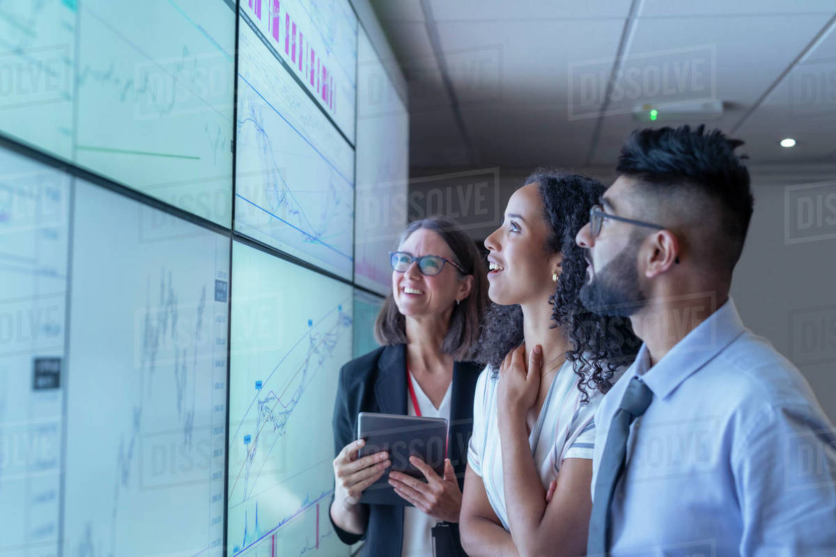 Business people discussing charts on interactive screens - Stock Photo ...