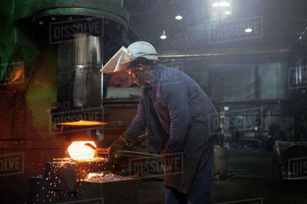 Forge worker pre forms steel billet - Royalty-free Stock Photo | Dissolve