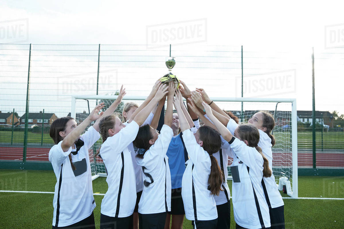 Young Girls' Soccer Team holding trophy in soccer field - Royalty-free ...
