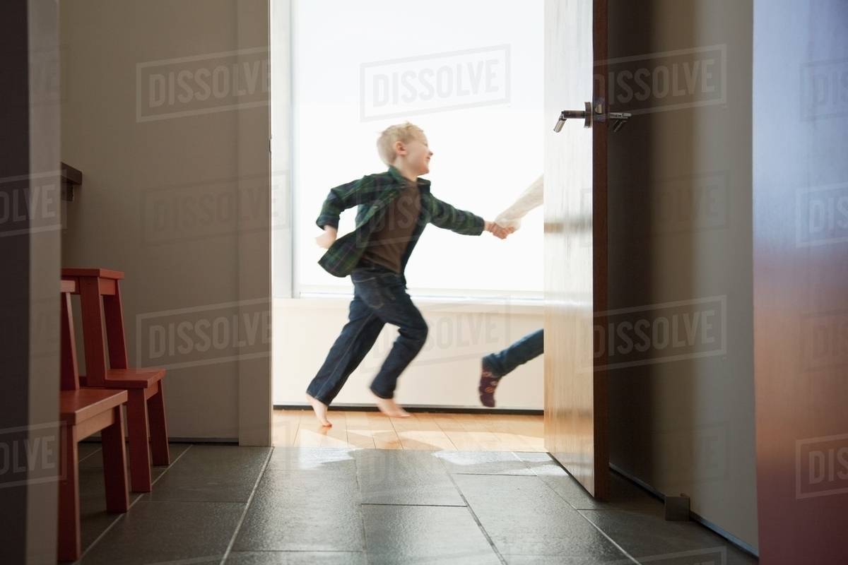 Two children running past doorway - Stock Photo - Dissolve