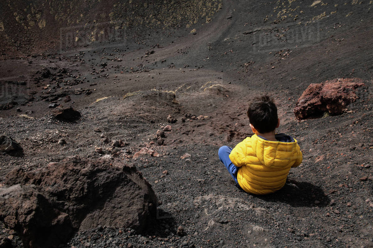 Italy, Sicily, Boy sitting in Etna volcano - Royalty-free Stock Photo ...