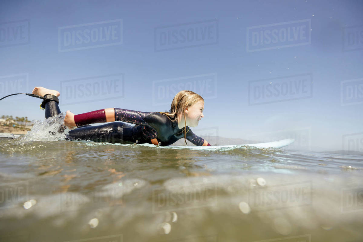 Girl surfing in the ocean - Royalty-free Stock Photo | Dissolve