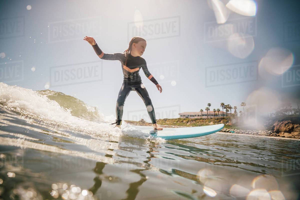 Girl surfing in the ocean - Stock Photo - Dissolve