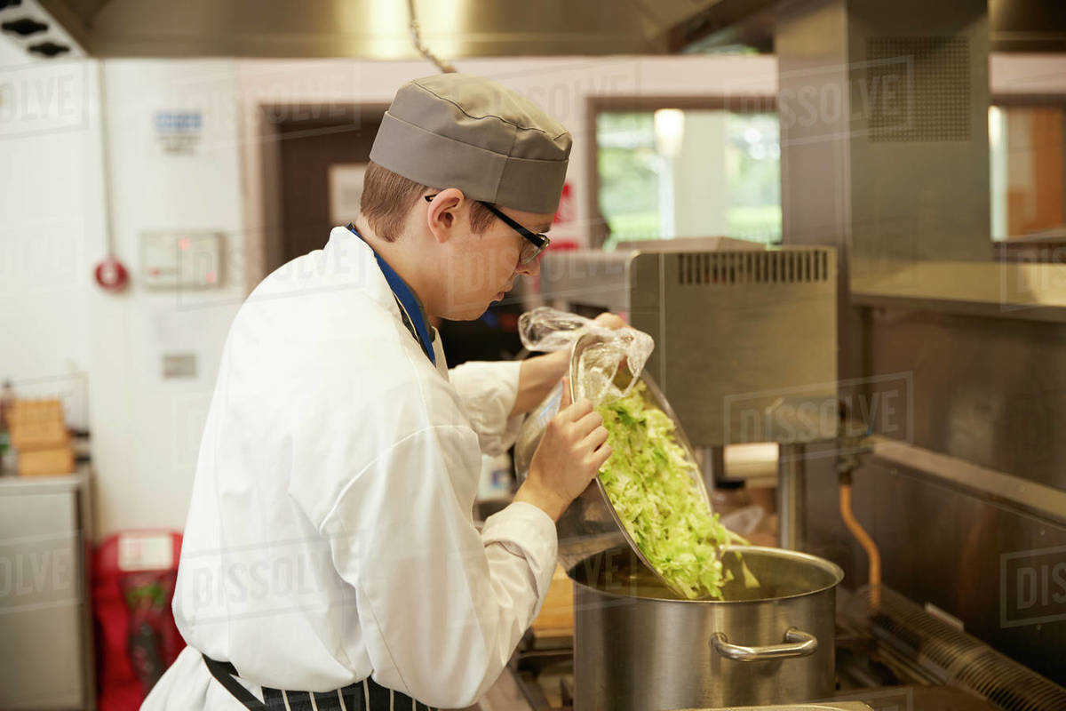 Male cook working in kitchen - Stock Photo - Dissolve